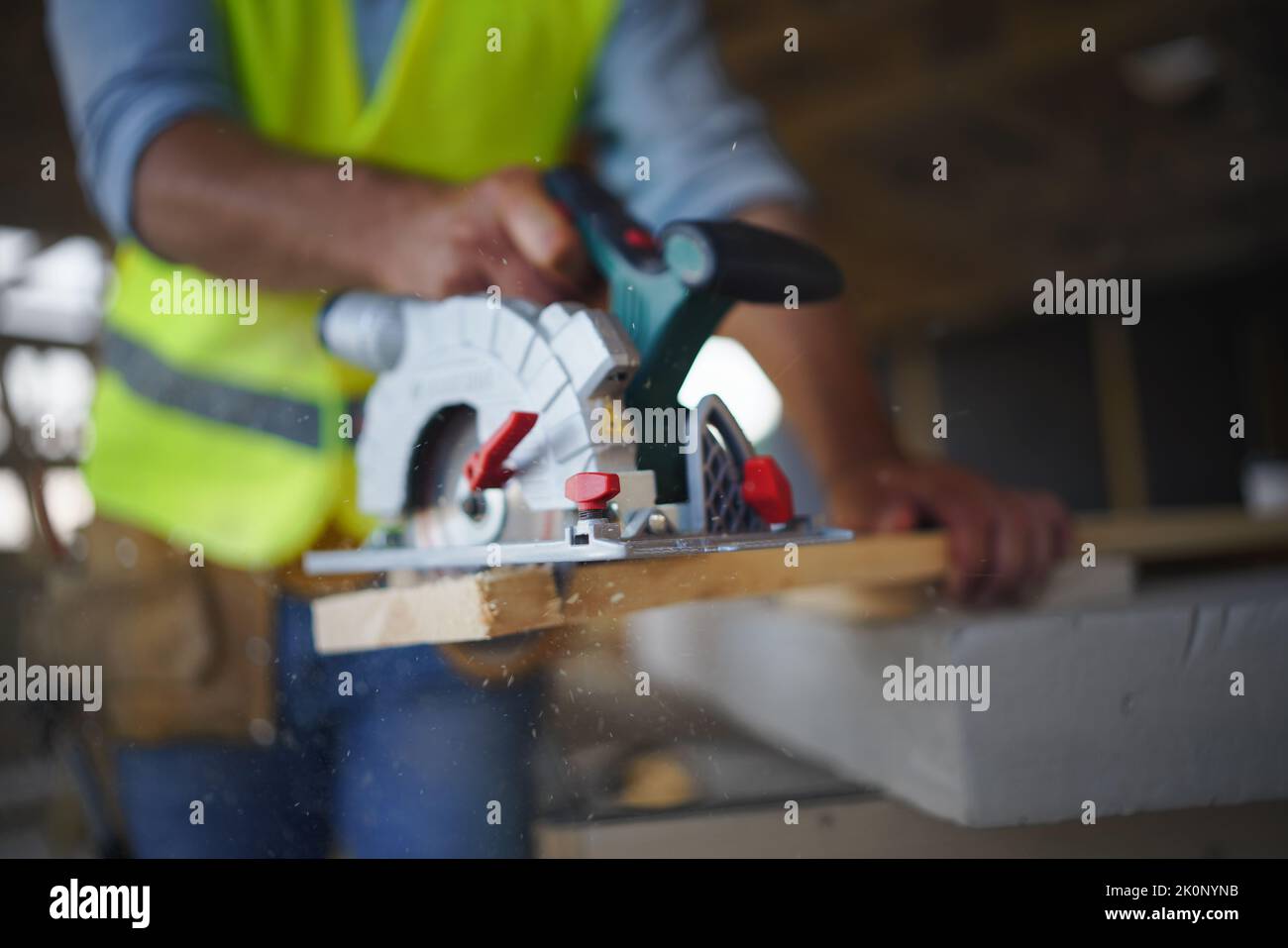 Close-up of construction worker working with eletric saw inside wooden ...