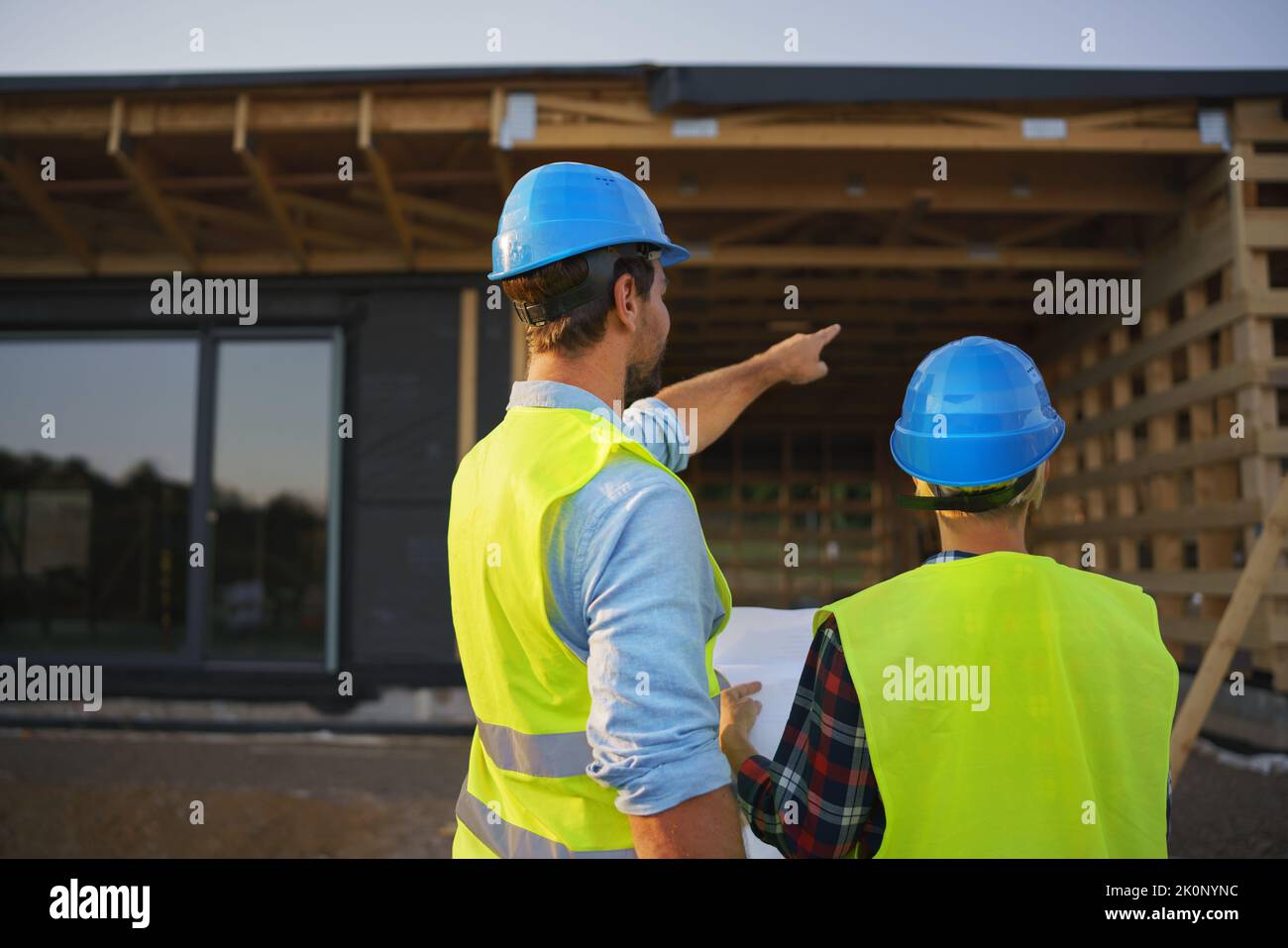 Construction engineers or architects with blueprints checking eco ...