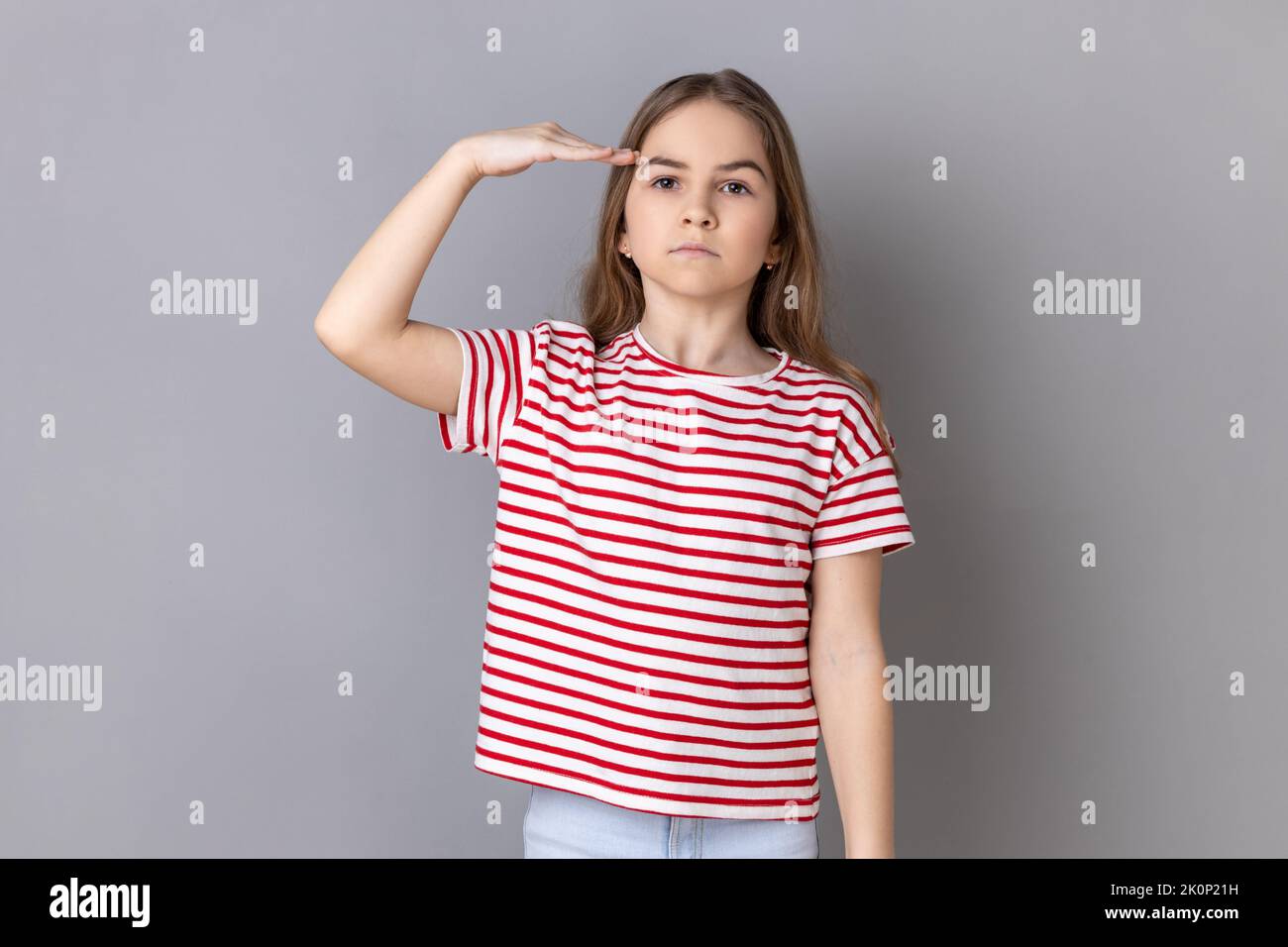 Portrait of serious bossy dark haired little girl wearing striped T ...