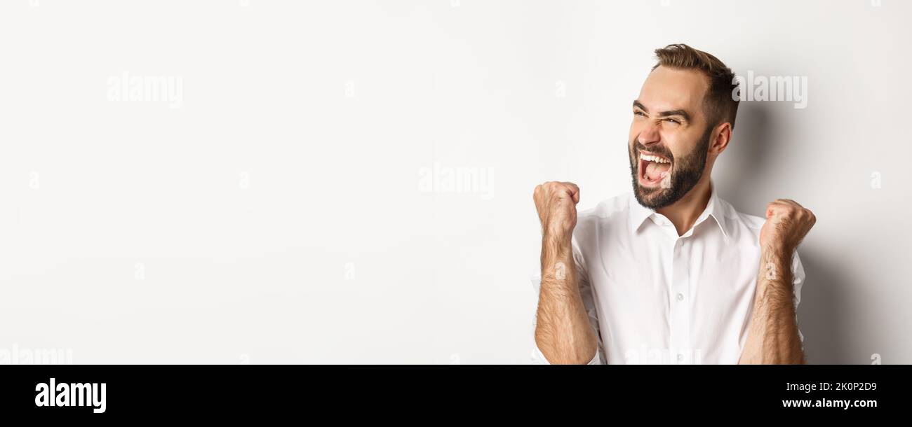 Close-up of successful caucasian man rejoicing, making fist pump and ...