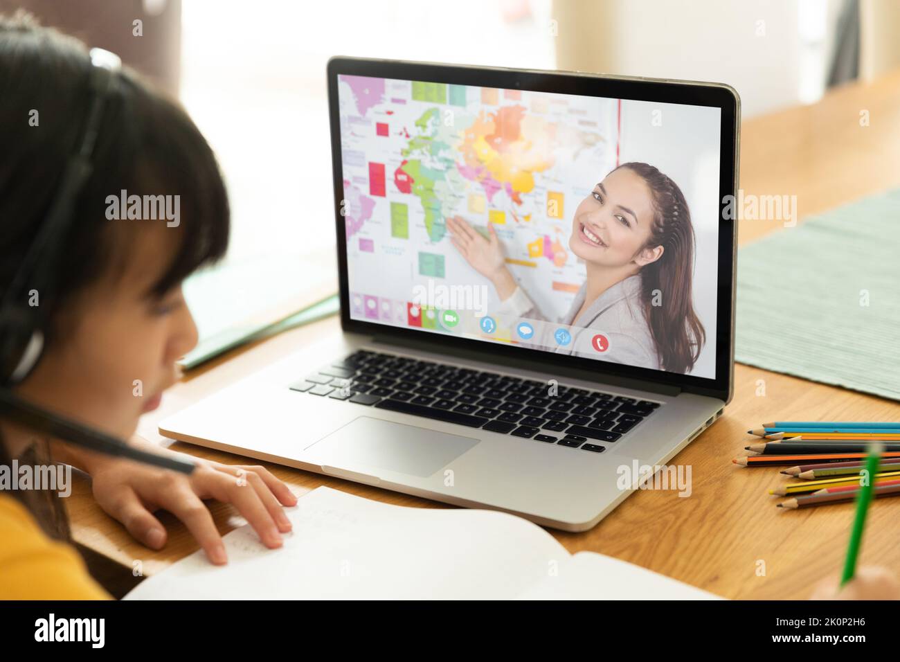 Asian girl using laptop for video call, with smiling female teacher on ...