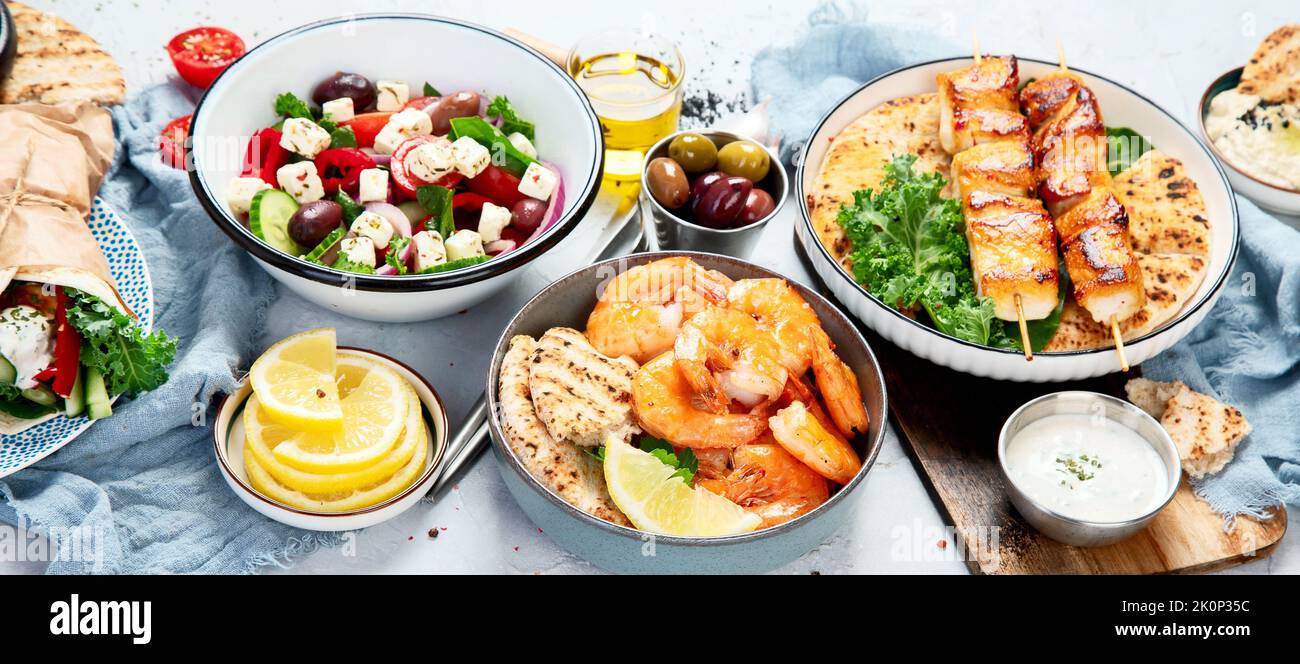 Greek food background. Meze, gyros, souvlaki, fish, pita, greek salad ...