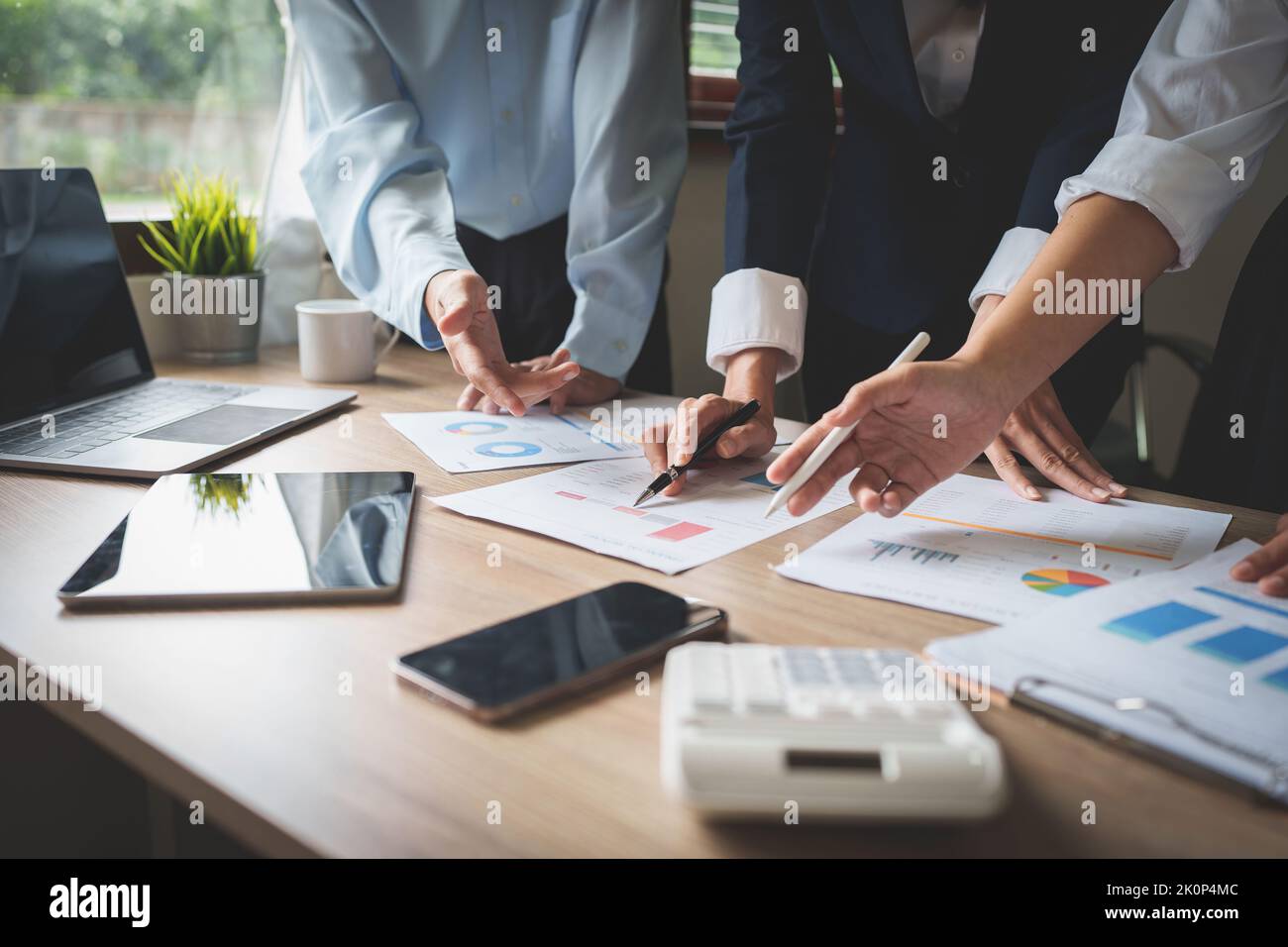 Business team using calculator to calculate the company's financial ...