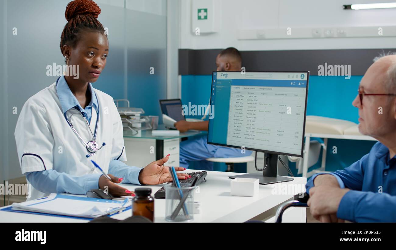 Female physician consulting elderly man with physical impairment ...