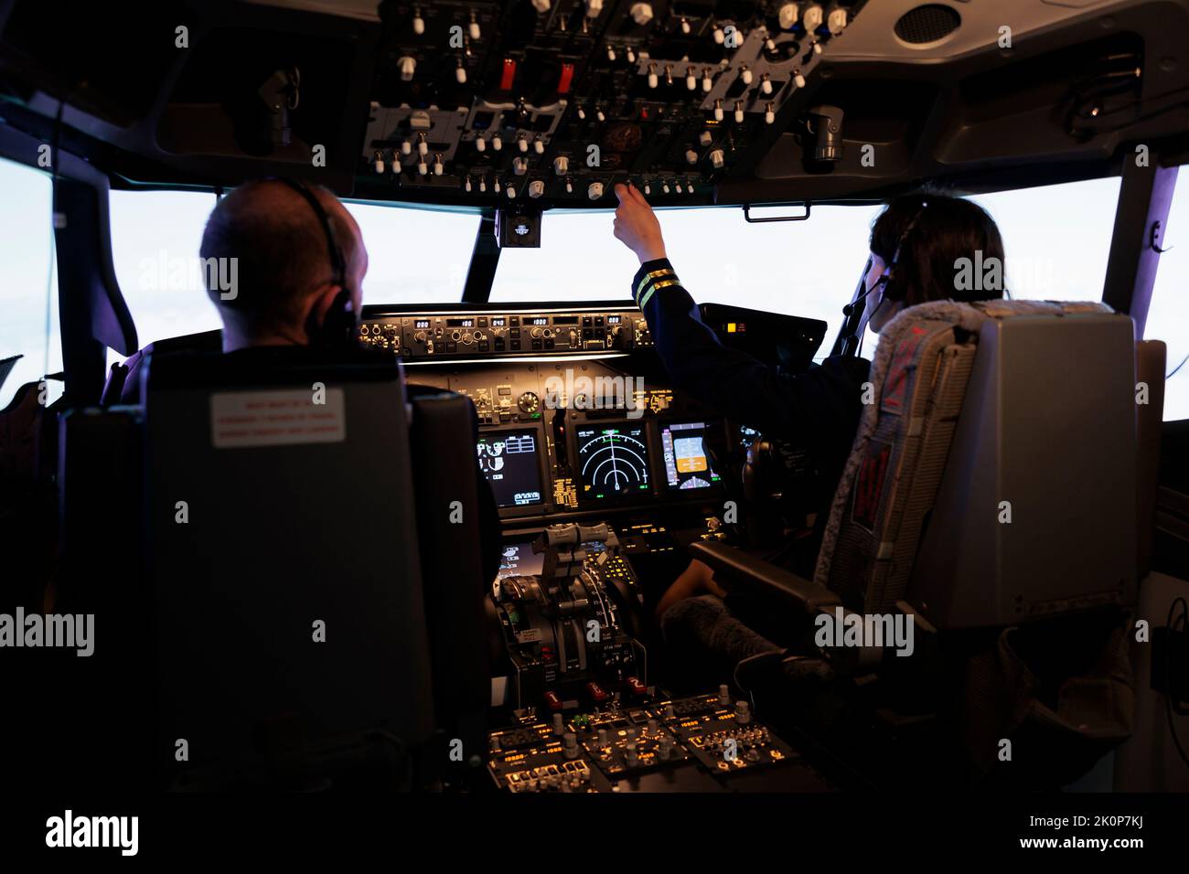 Woman Copilot Assisting Captain To Takeoff And Fly Airplane Using Buttons On Dashboard Command