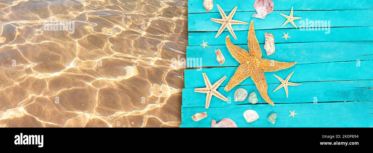 Starfish, shells on wooden blue boards of pier with clear water of sea ...