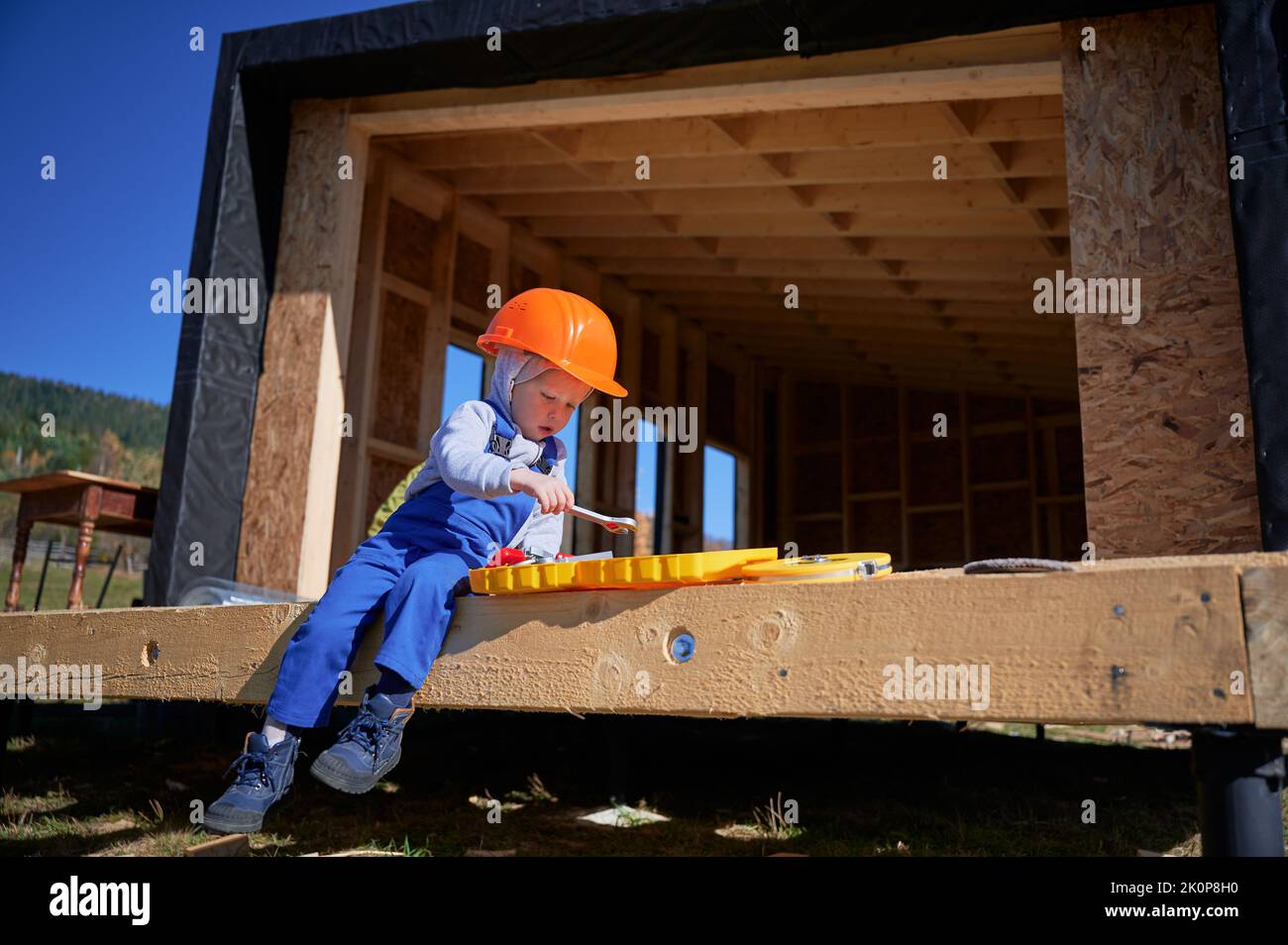 Boy toddler playing as builder on construction site. Child carpenter in ...