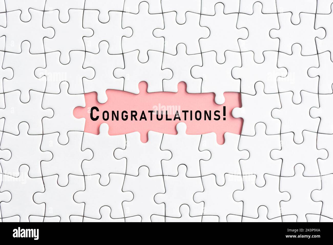 White jigsaw puzzle with congratulations word over pink background ...