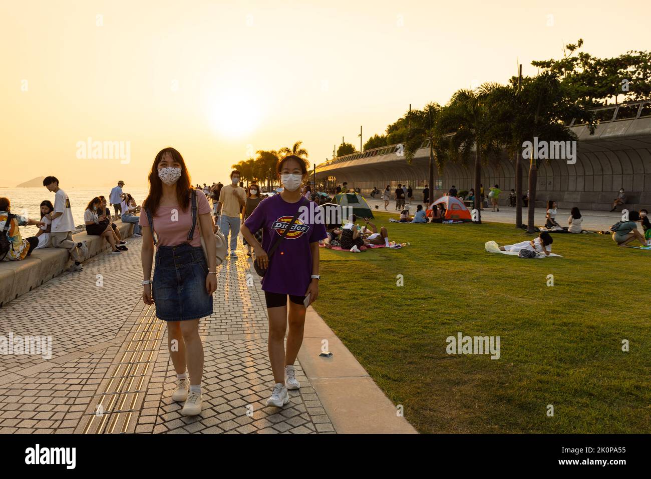 youngsters students boy and girl chat and walk during sunset in West Kowloon Waterfront ...