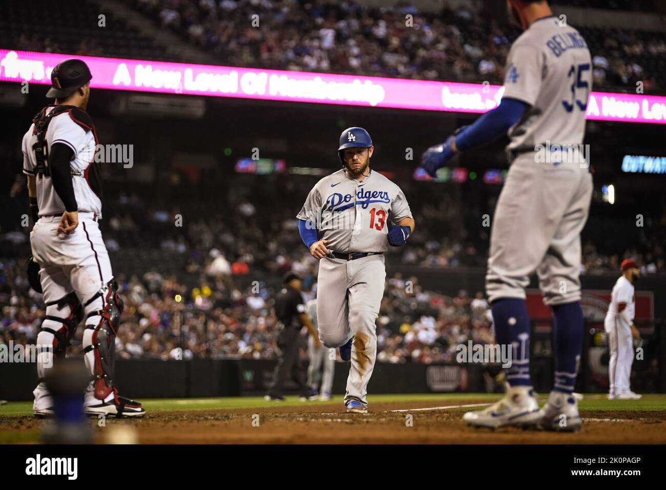 Los Angeles Dodgers third baseman Max Muncy (13) scores on a sacrifice ...