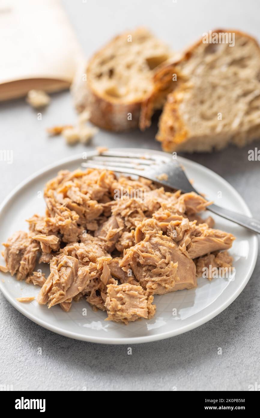 Canned tuna fish on the plate on kitchen table Stock Photo - Alamy