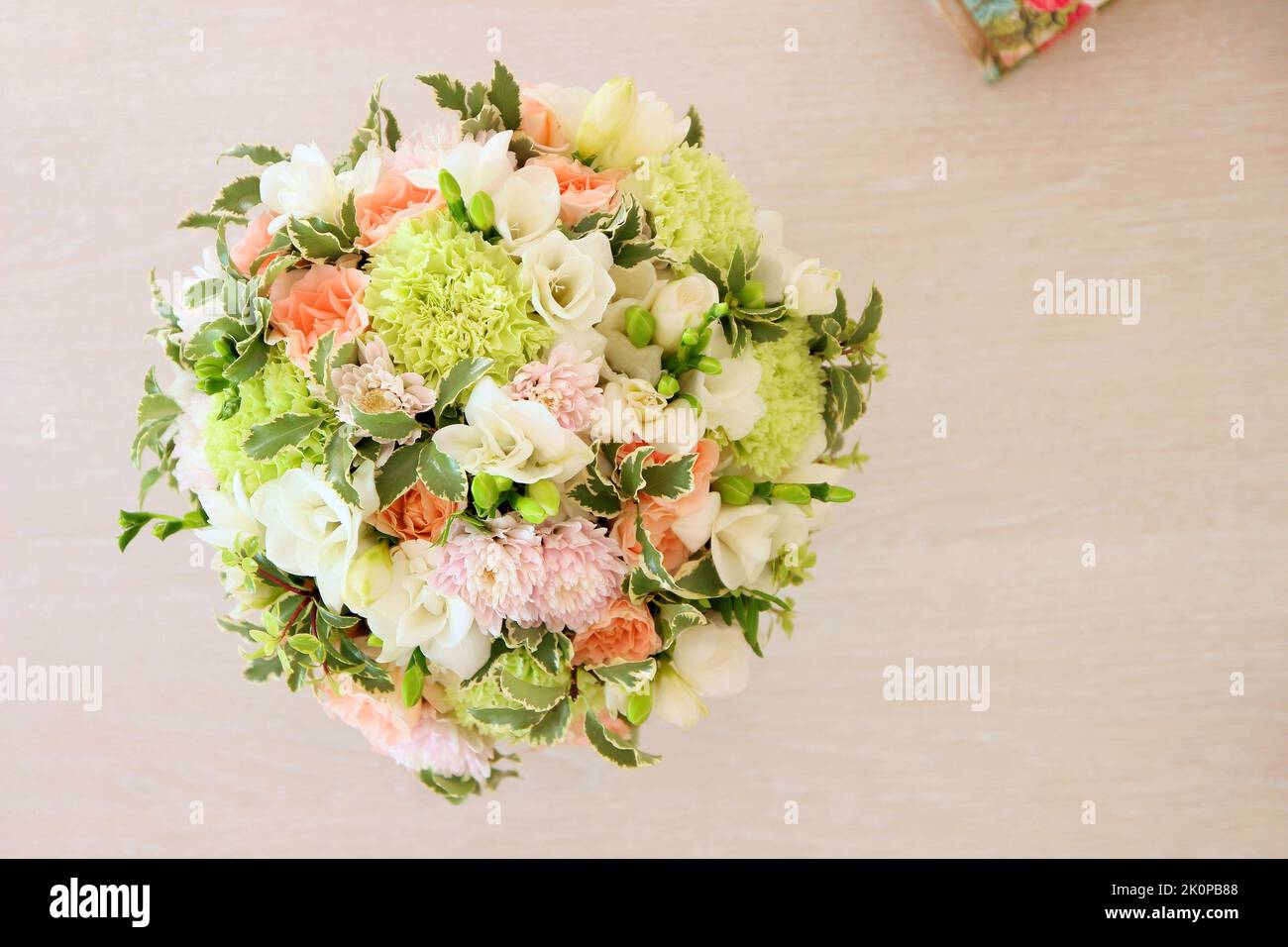 Round mint and peach colors bouquet and book on pink background. It ...