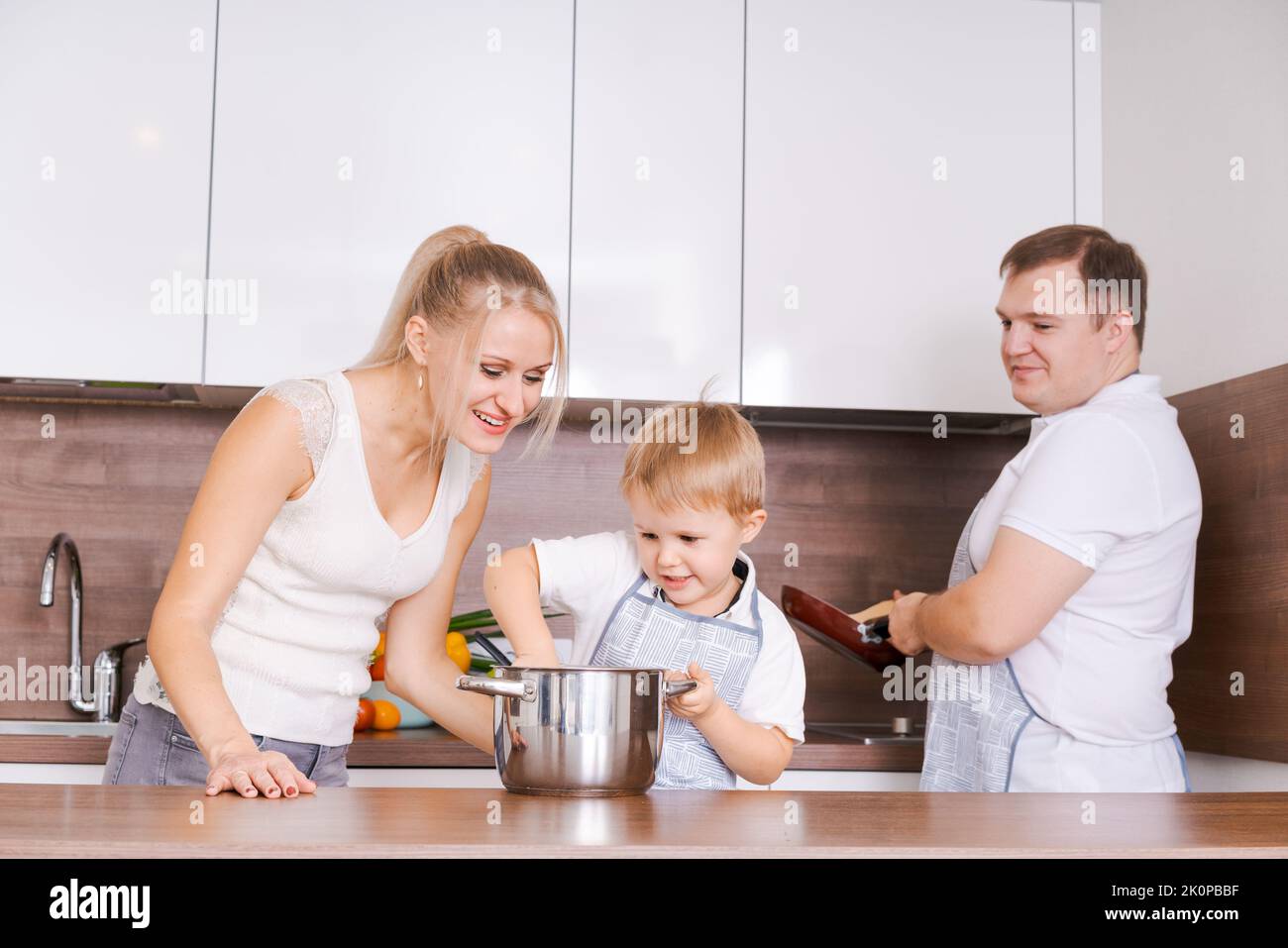 Family mom son, dad are preparing delicious food in kitchen. Mom ...