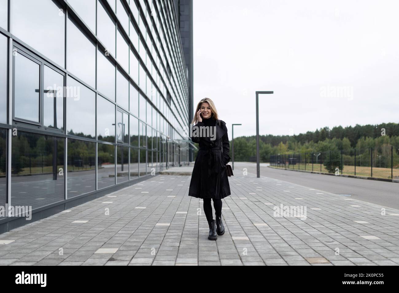Middle-aged business woman rushing to work next to an office building ...