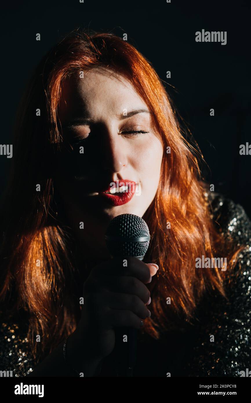 Portrait of redhead female singer woman in sparkly evening dress ...