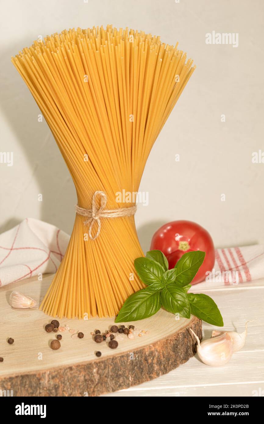 On the table is a pack of spaghetti tied with string. On a light ...