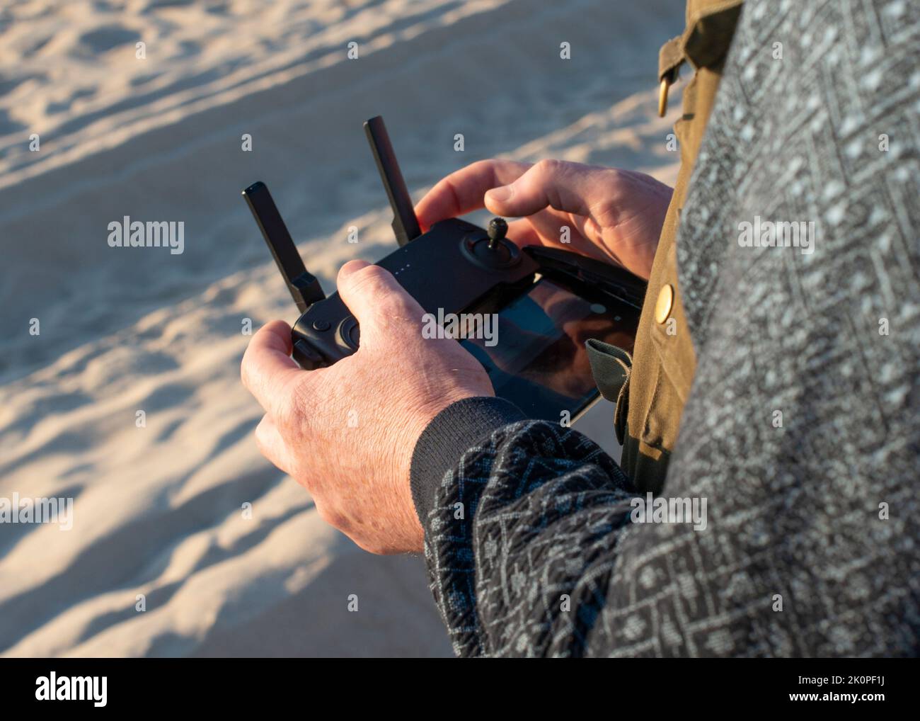 Male hands holding drone remote controller. Cropped shot, close up ...