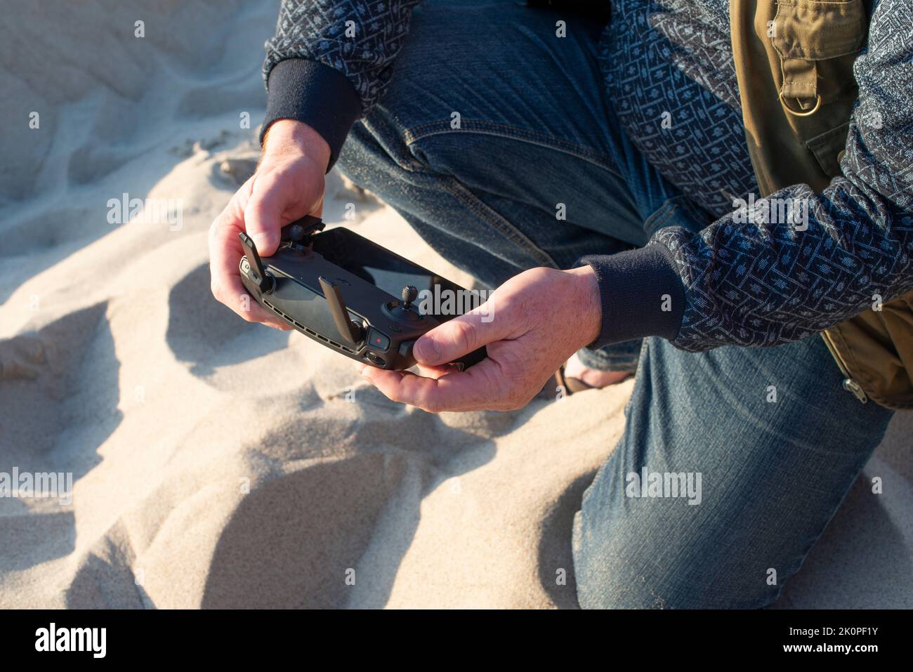 Male hands holding drone remote controller. Cropped shot, close up ...