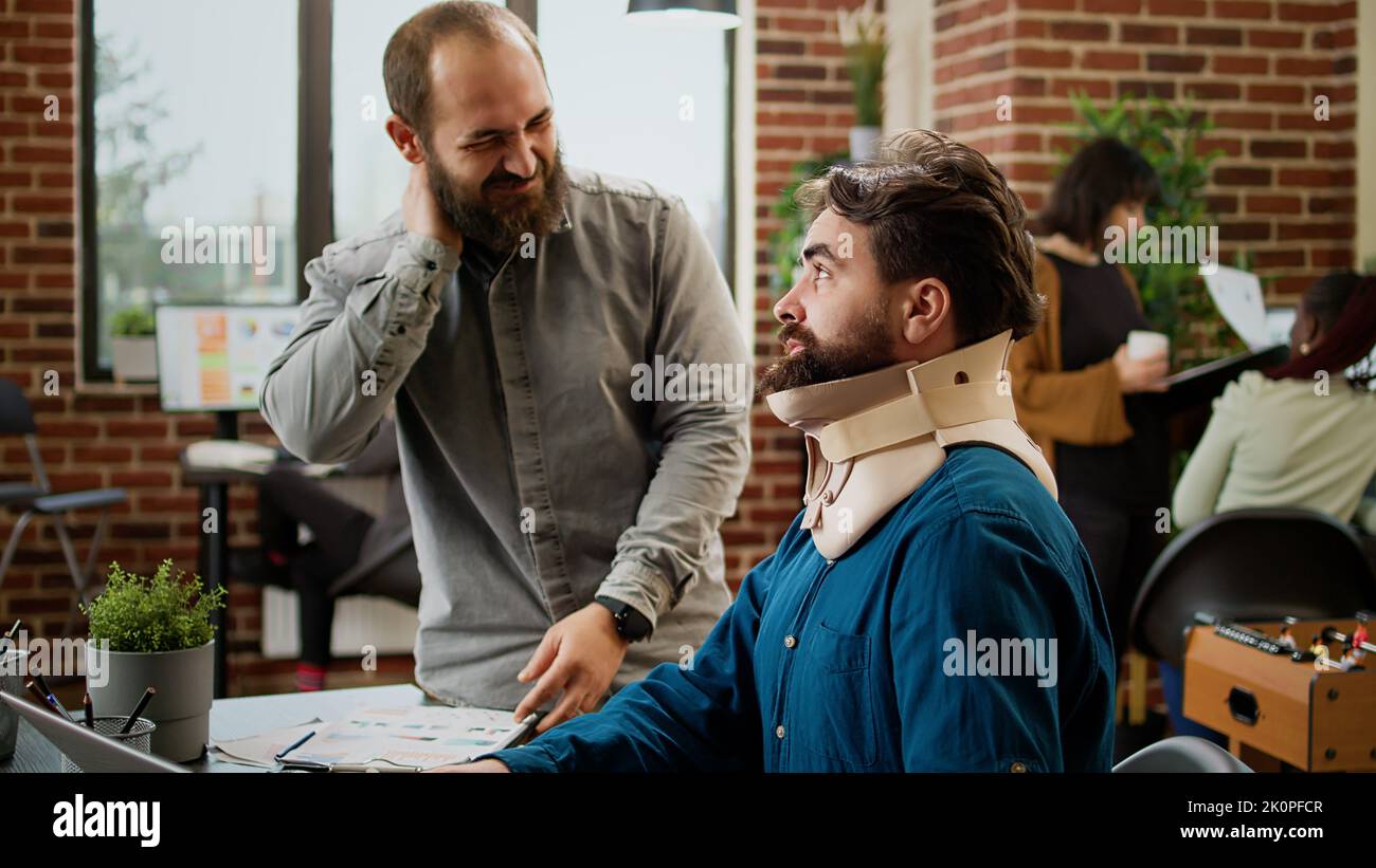 Business man in pain wearing cervical neck foam at office job, working ...