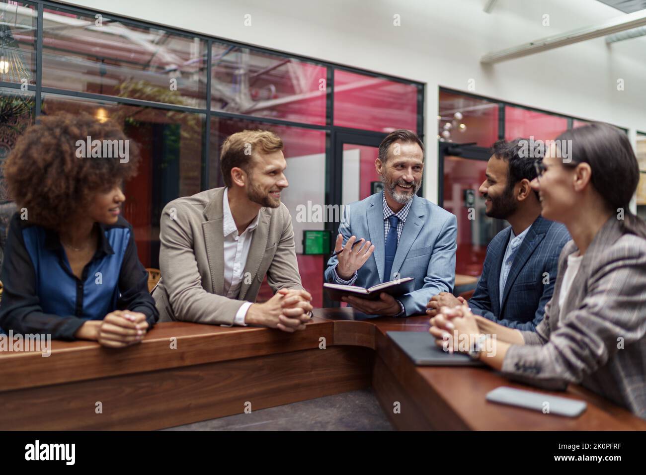 Businesspeople talking while standing in office during break. Teamwork ...