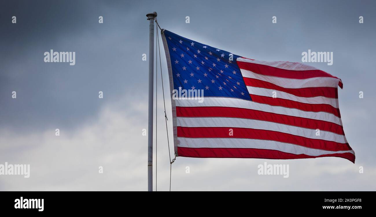 American flag moving in the wind with storm clouds behind Stock Photo ...