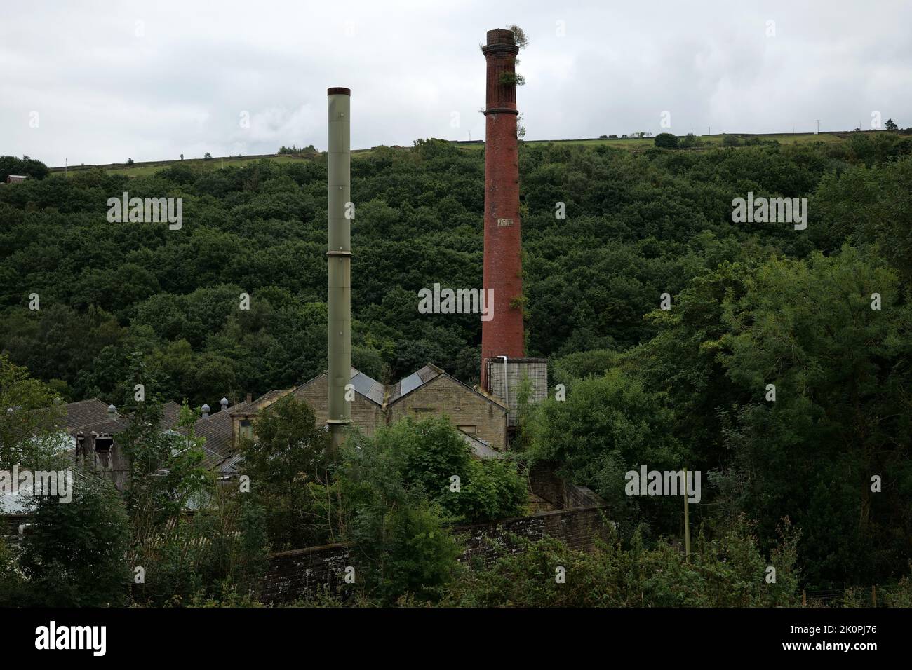 Old industrial building with two chimneys among trees Stock Photo - Alamy
