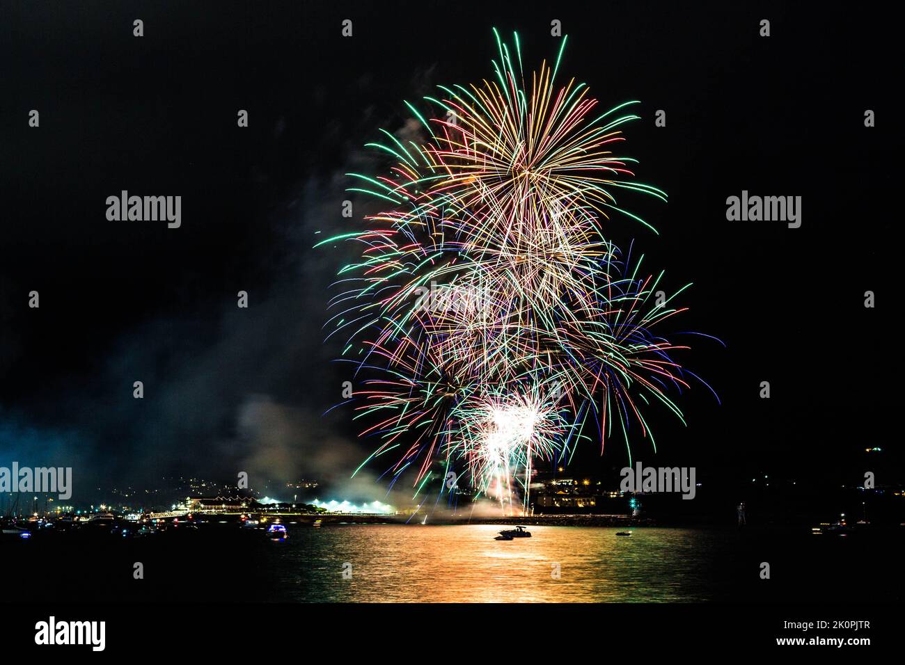 A beautiful view of the colorful fireworks over the water Stock Photo ...