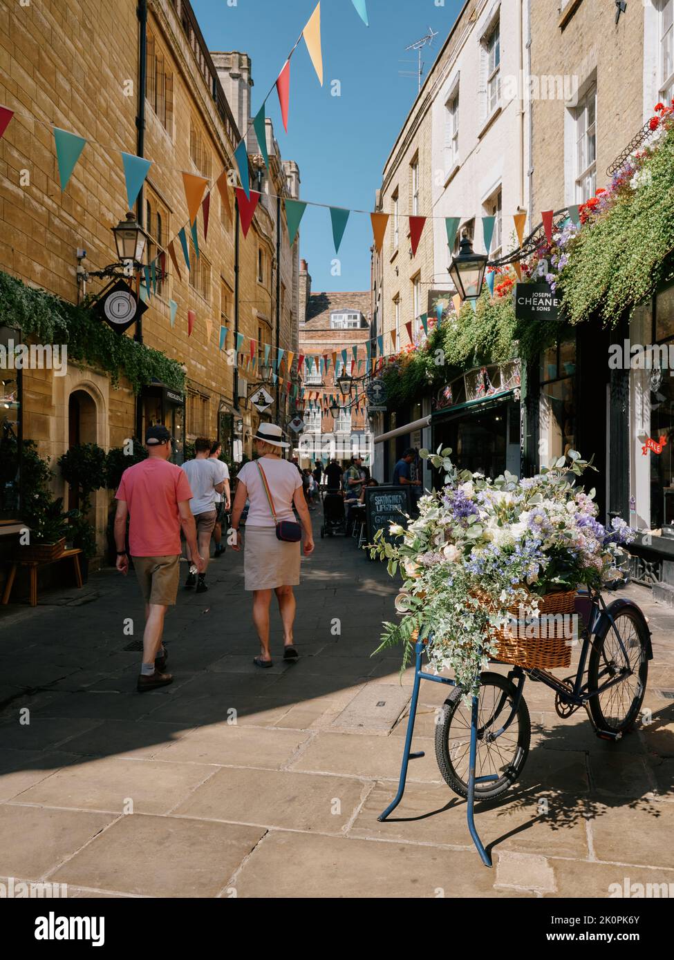 Shoppers, tourists, bunting and the limestone architecture of shop ...