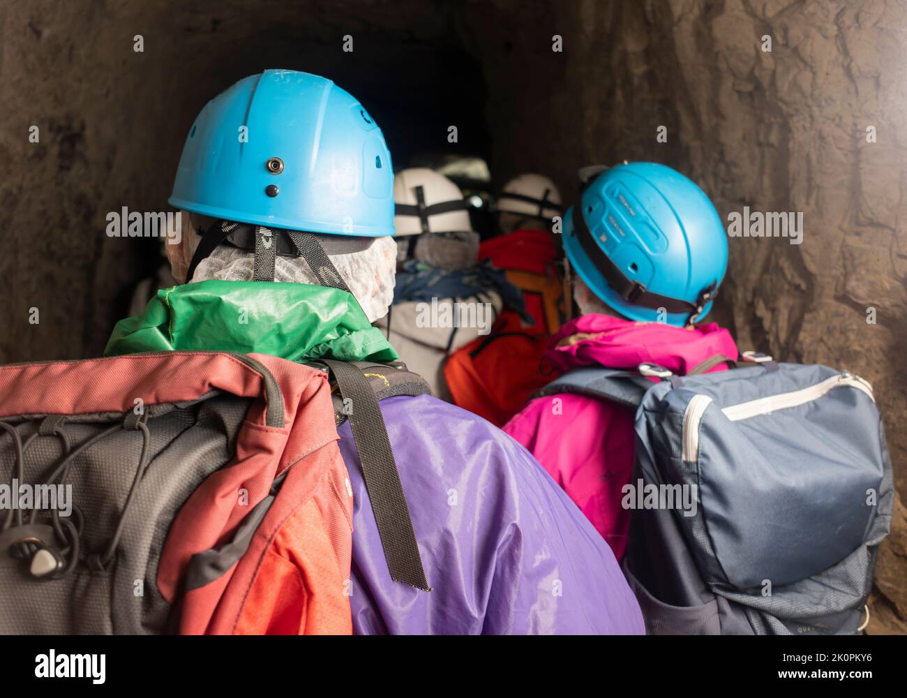 Three unidentified elderly people enter the cave to go caving. Dressed ...