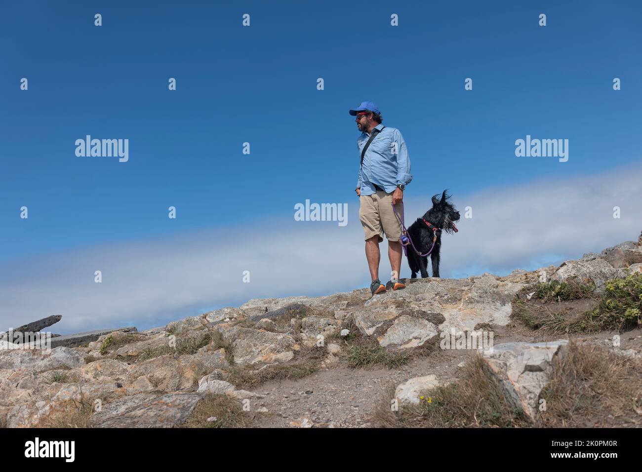 Young adventurer walking near cliff with dog Stock Photo - Alamy