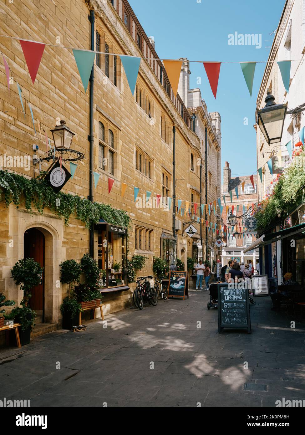 Shoppers, tourists, bunting and the limestone architecture of shop ...