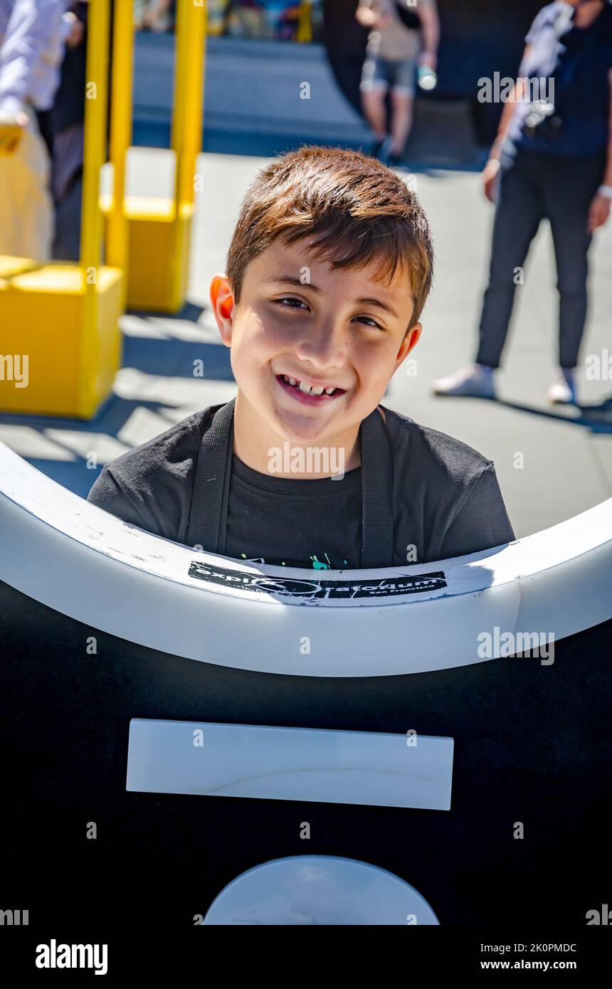 Portrait of a boy peering through the circular hole in an Exploratorium ...