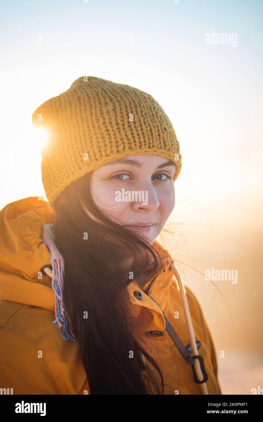 Traveller with a pleasant smile in a distinctive yellow jacket stands ...