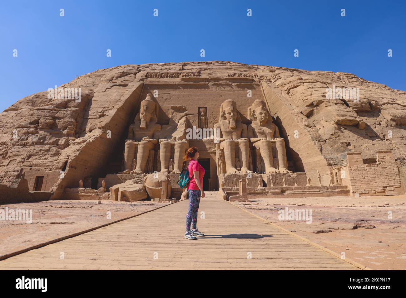 White Tourist in front of the Colossal Statues of Ramesses II seated on ...