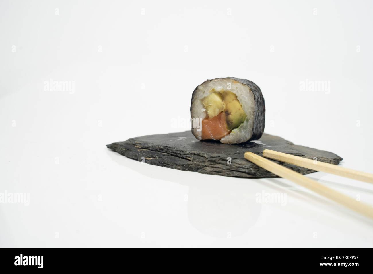 a piece of shushi with chopsticks in white background Stock Photo - Alamy