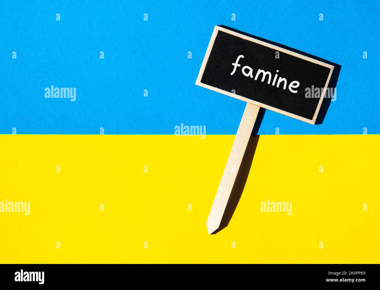 Wooden information label sign with text FAMINE against Ukrainian ...