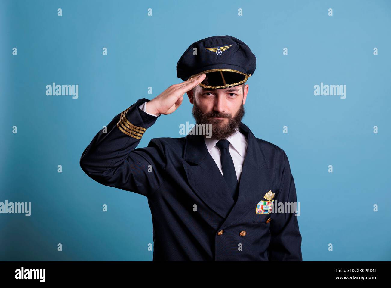 Smiling airplane aviator saluting, wearing uniform and hat front view ...