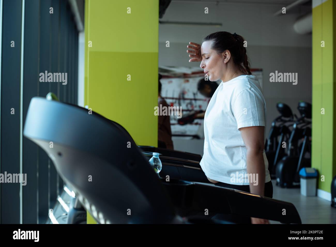 Fat woman run on treadmill at fitness gym wiping sweat from face by ...