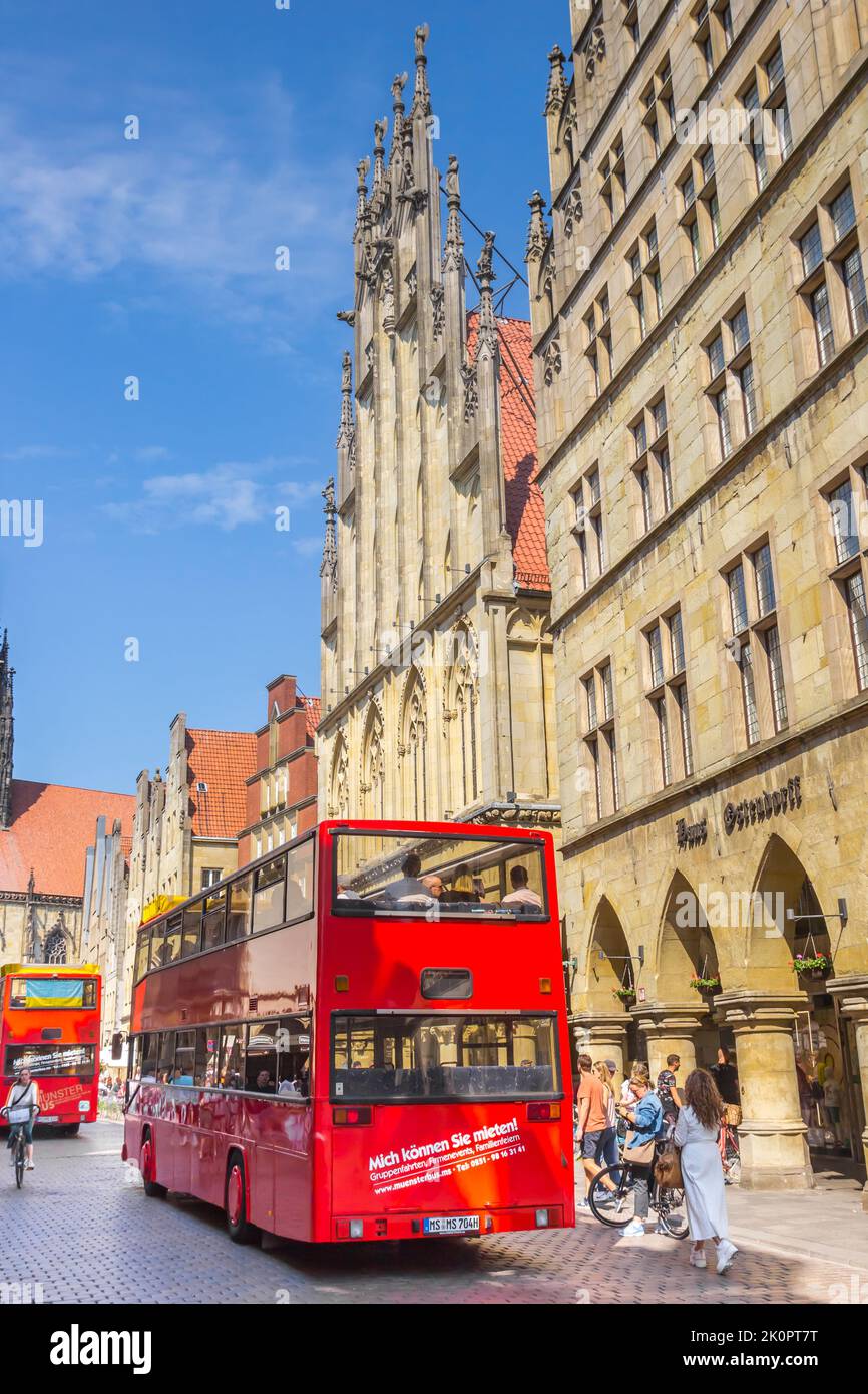 Red sightseeing bus in front of the historic town hall in Munster ...