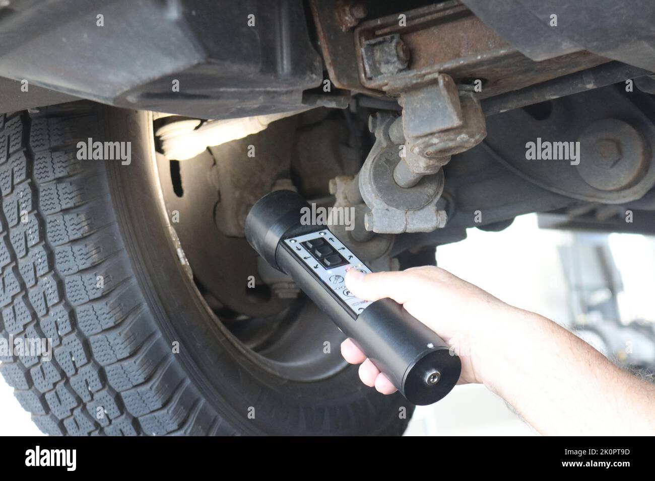 Car mechanic checking the wheel under the car in the pit Stock Photo ...