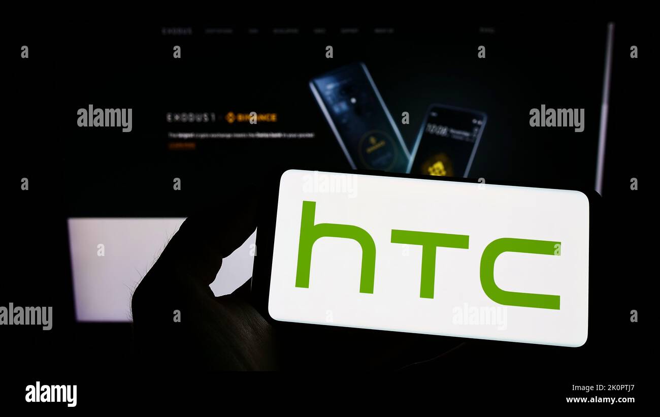 Person holding cellphone with logo of Taiwanese electronics company HTC ...
