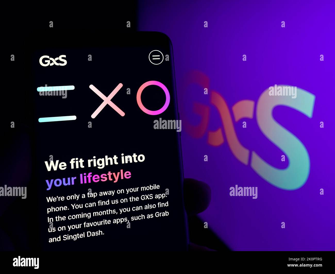 Person holding smartphone with website of Singaporean company GXS Bank ...