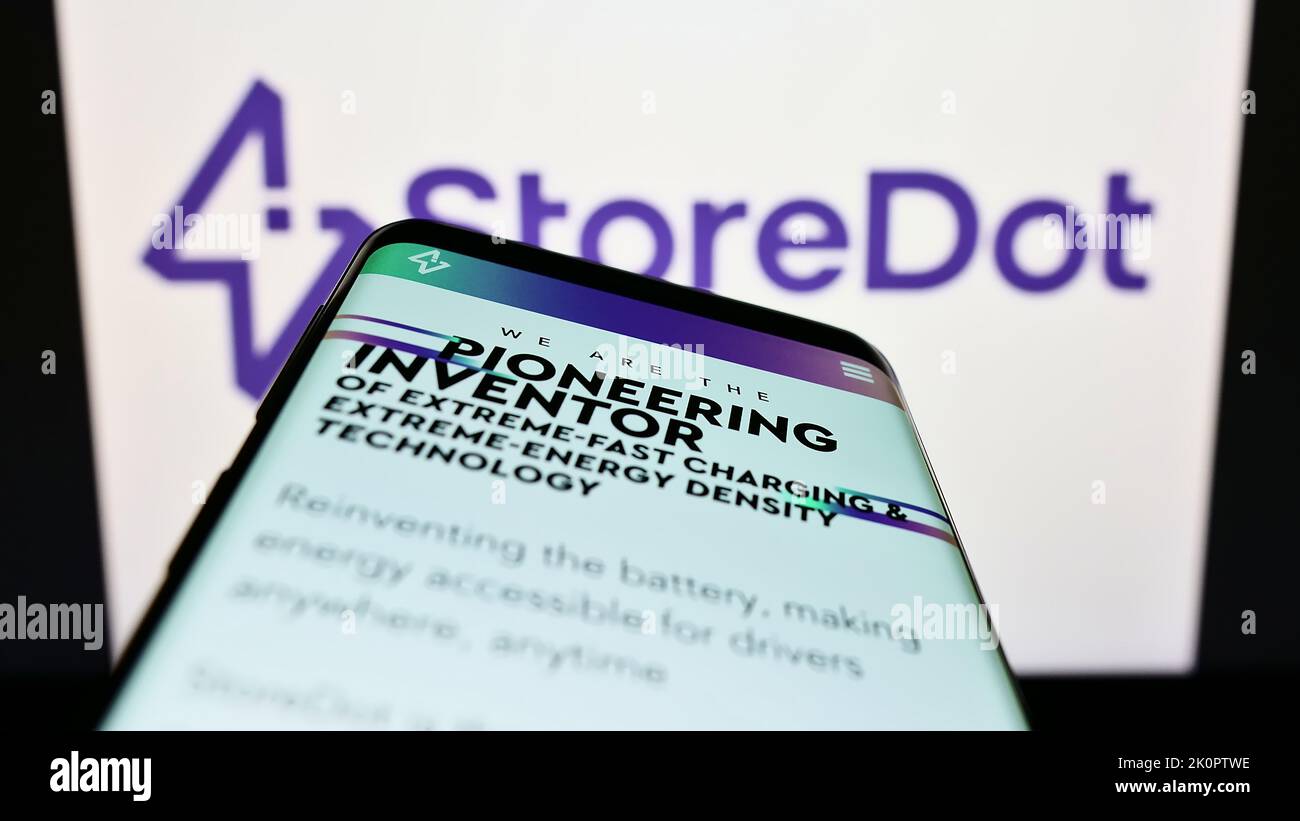 Mobile phone with webpage of Israeli battery company StoreDot Ltd. on screen in front of ...