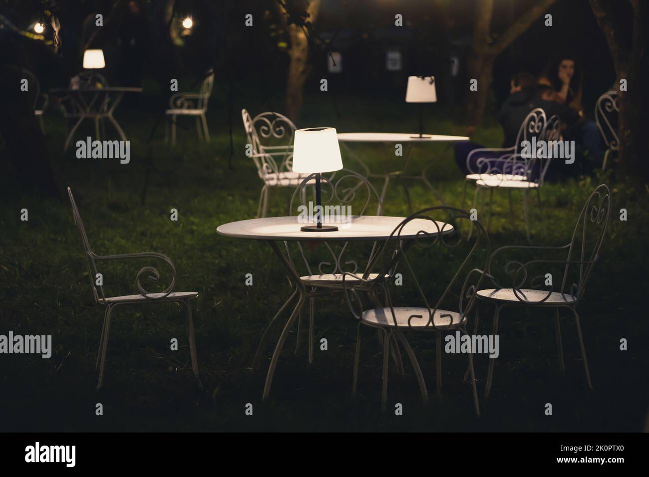 Victorian style cafe with white empty metal chairs and tables in ...