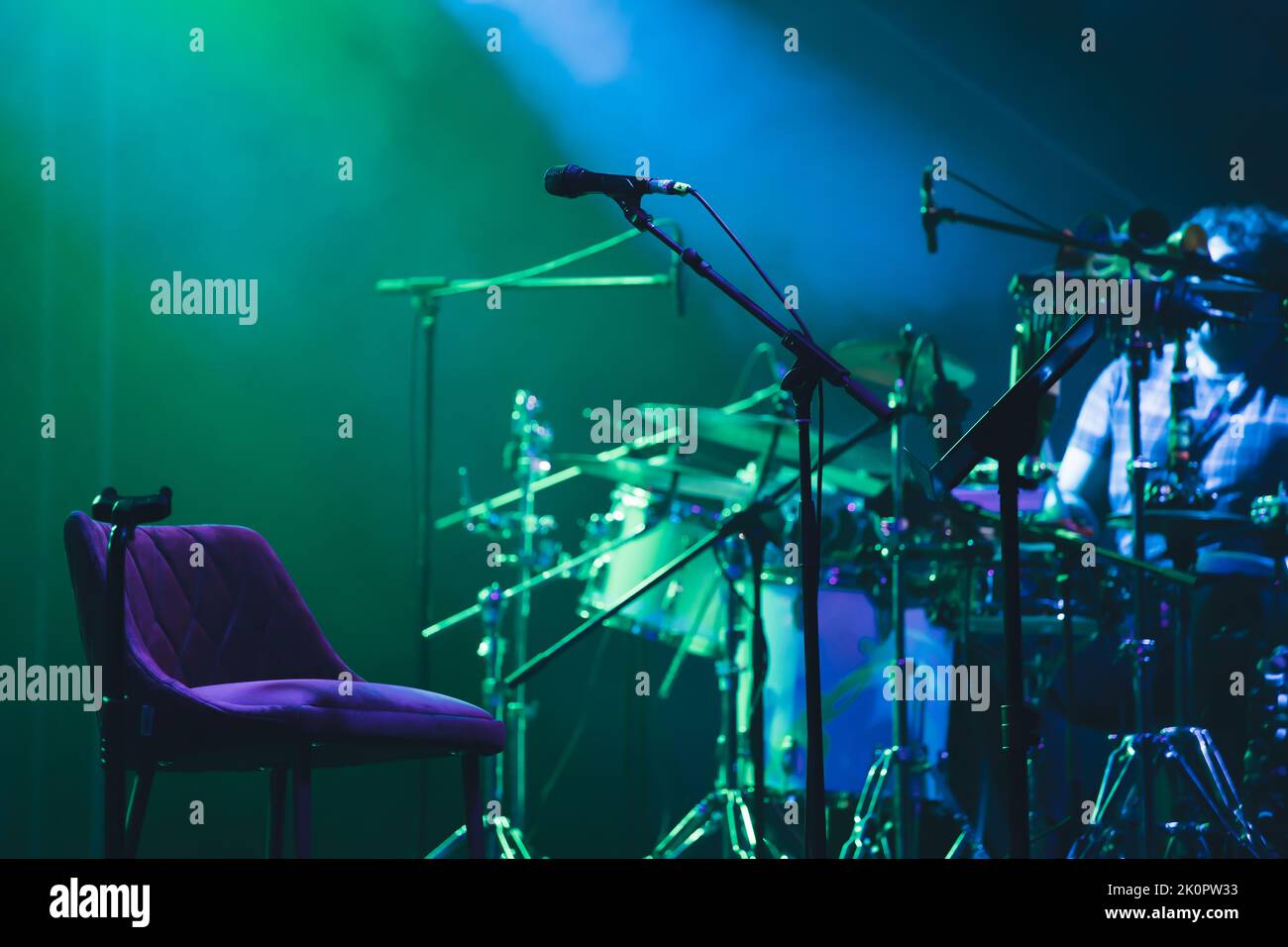 Microphone in colored spotlights and smoke. Concert and theatre scene ...