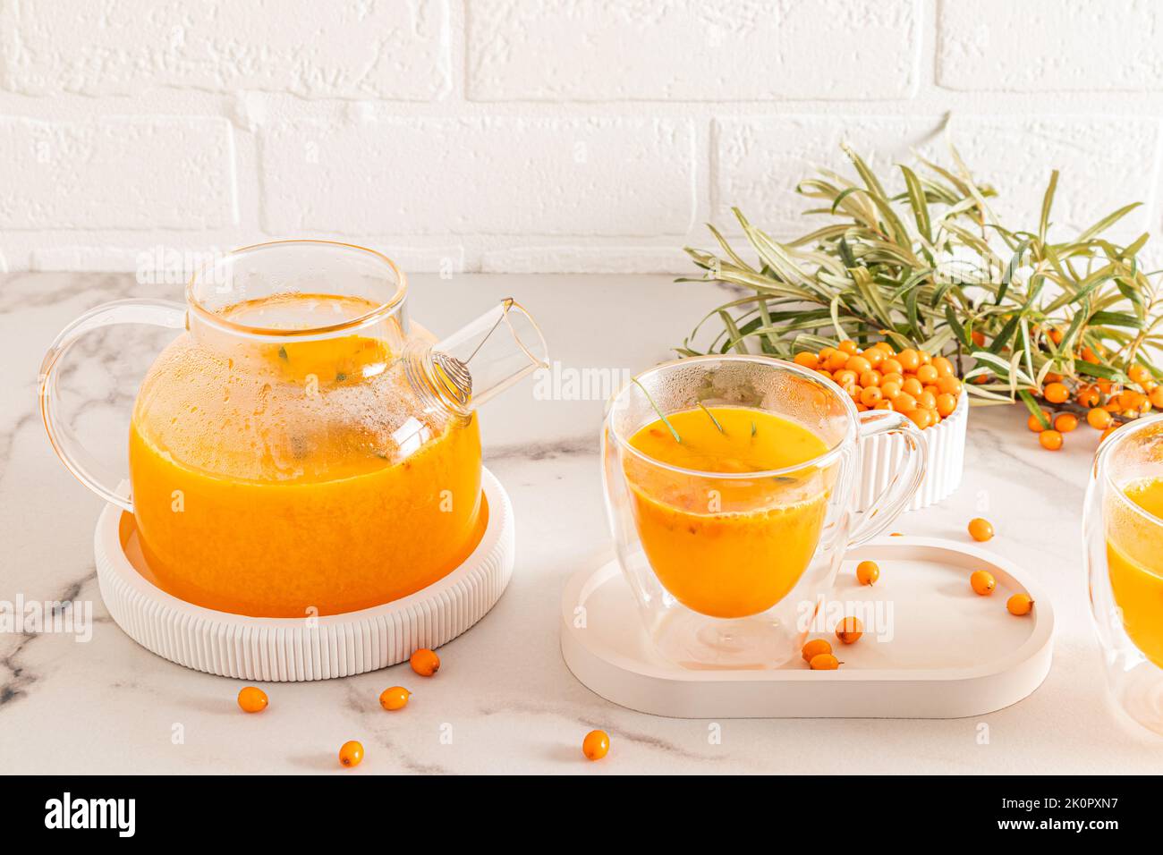 a large glass teapot with hot traditional seasonal sea buckthorn tea ...