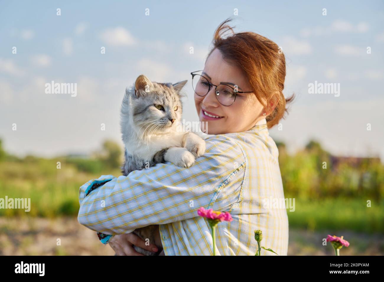 Outdoor portrait of middle aged woman with cat in her arms Stock Photo ...