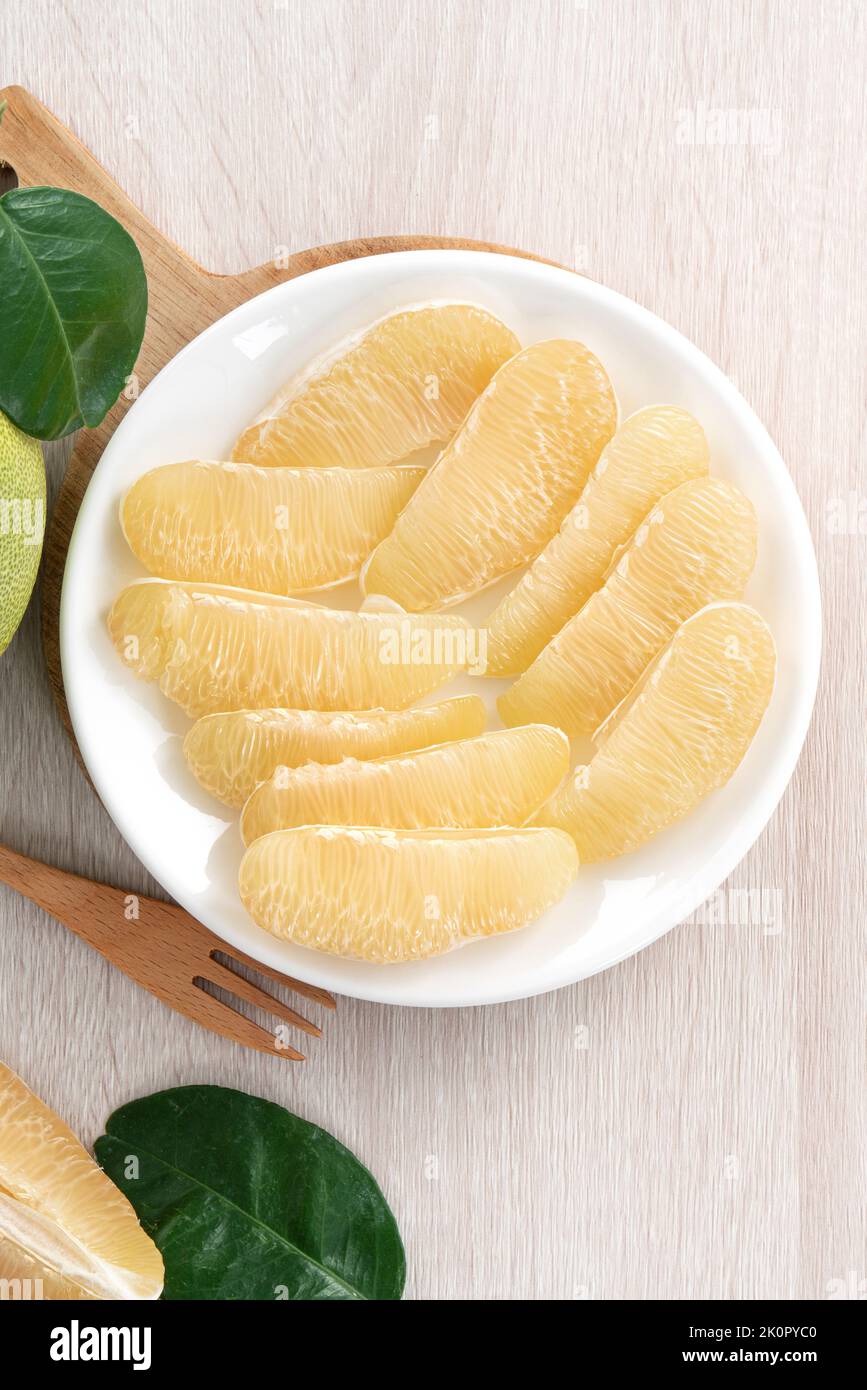 Top view of fresh peeled pomelo on bright wooden table background for ...