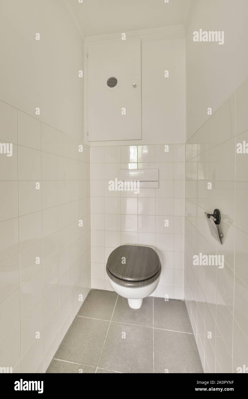 Flush toilet in small tiled restroom of contemporary apartment Stock ...