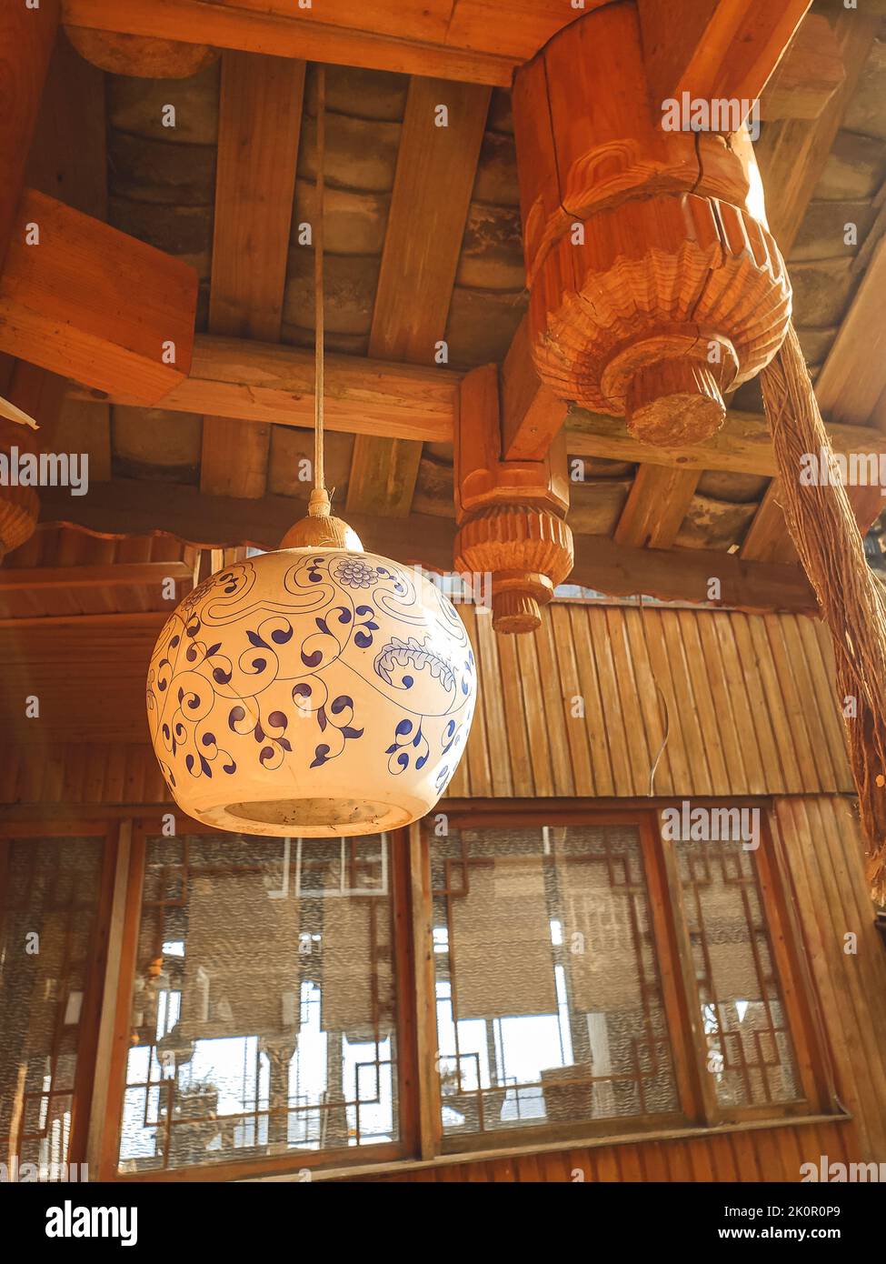 Hanging lamp with patterned lampshade under wooden ceiling of Chinese ...